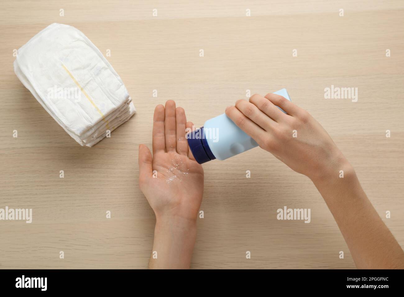 Woman applying dusting powder at wooden table, top view Stock Photo - Alamy