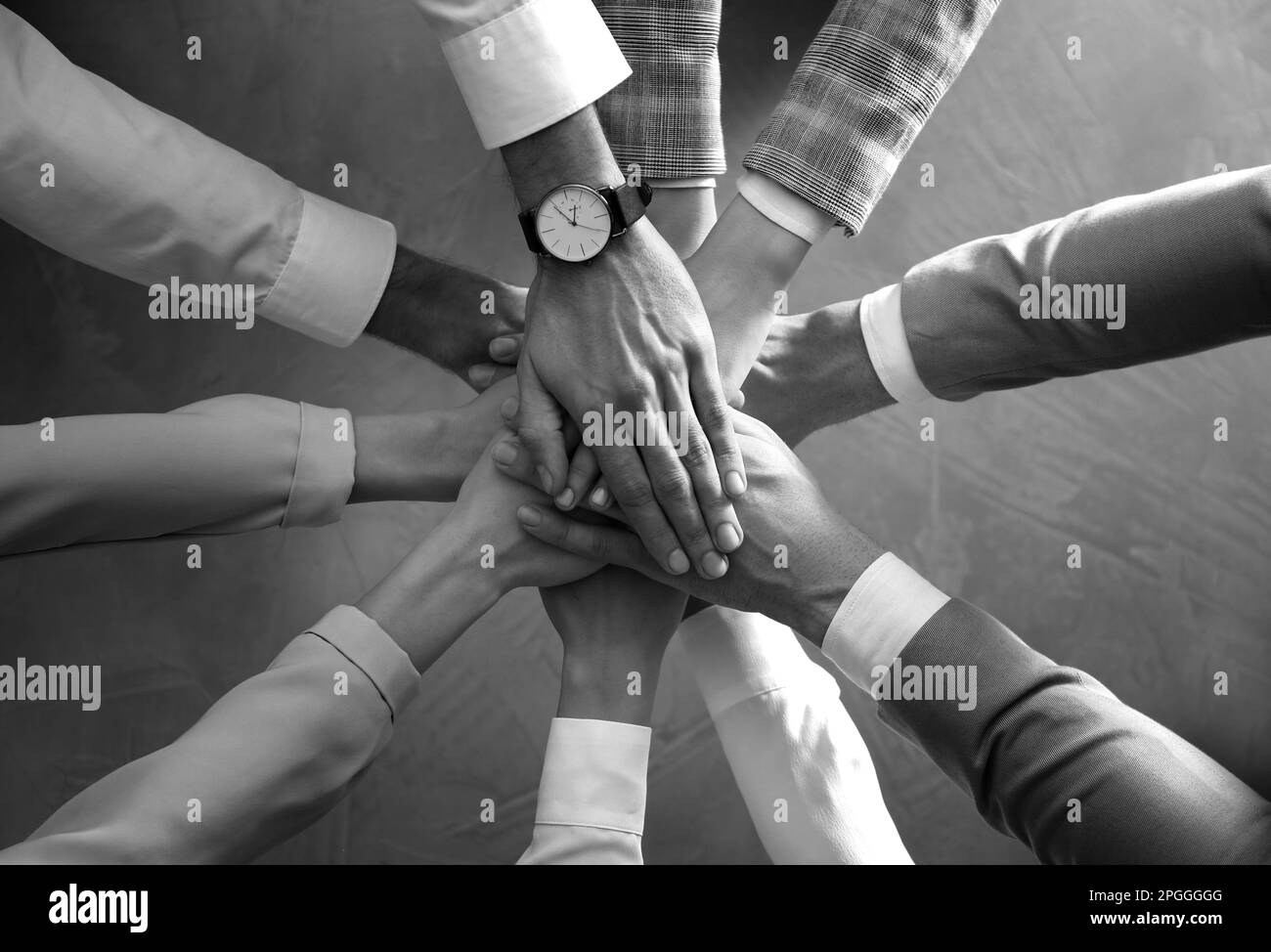 People holding hands together over stone background, top view. Unity ...
