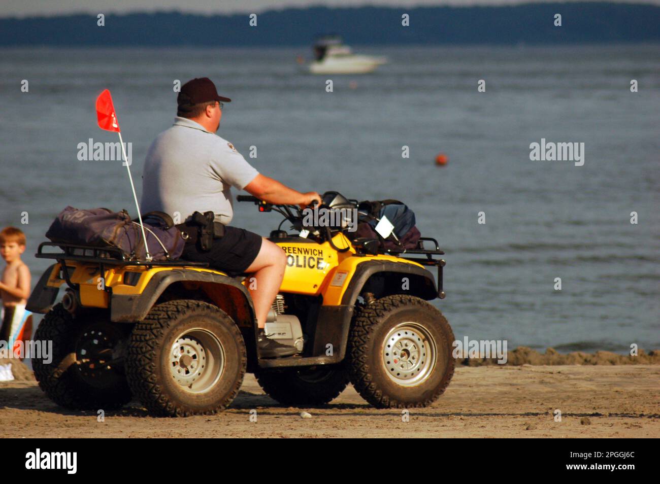 A police officer patrols the shoreline on a quad bike during a summer ...