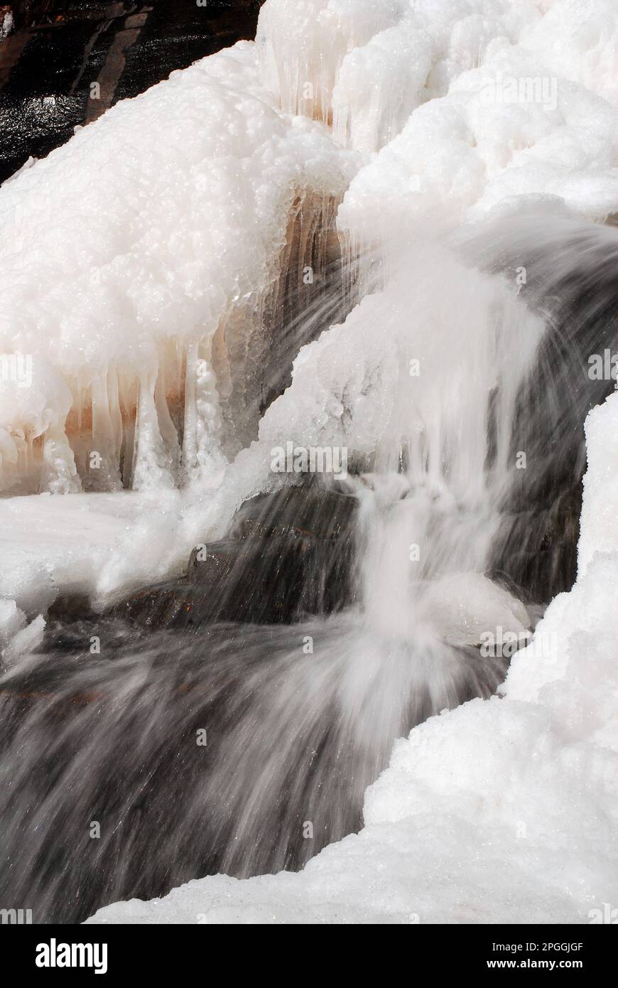 A waterfall continues to cascade despite the upper layer of frozen ice ...