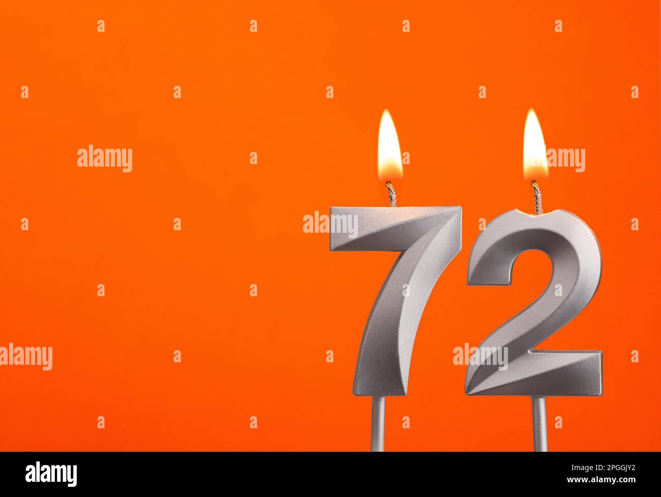 Candle number 72 - Birthday in orange background Stock Photo - Alamy