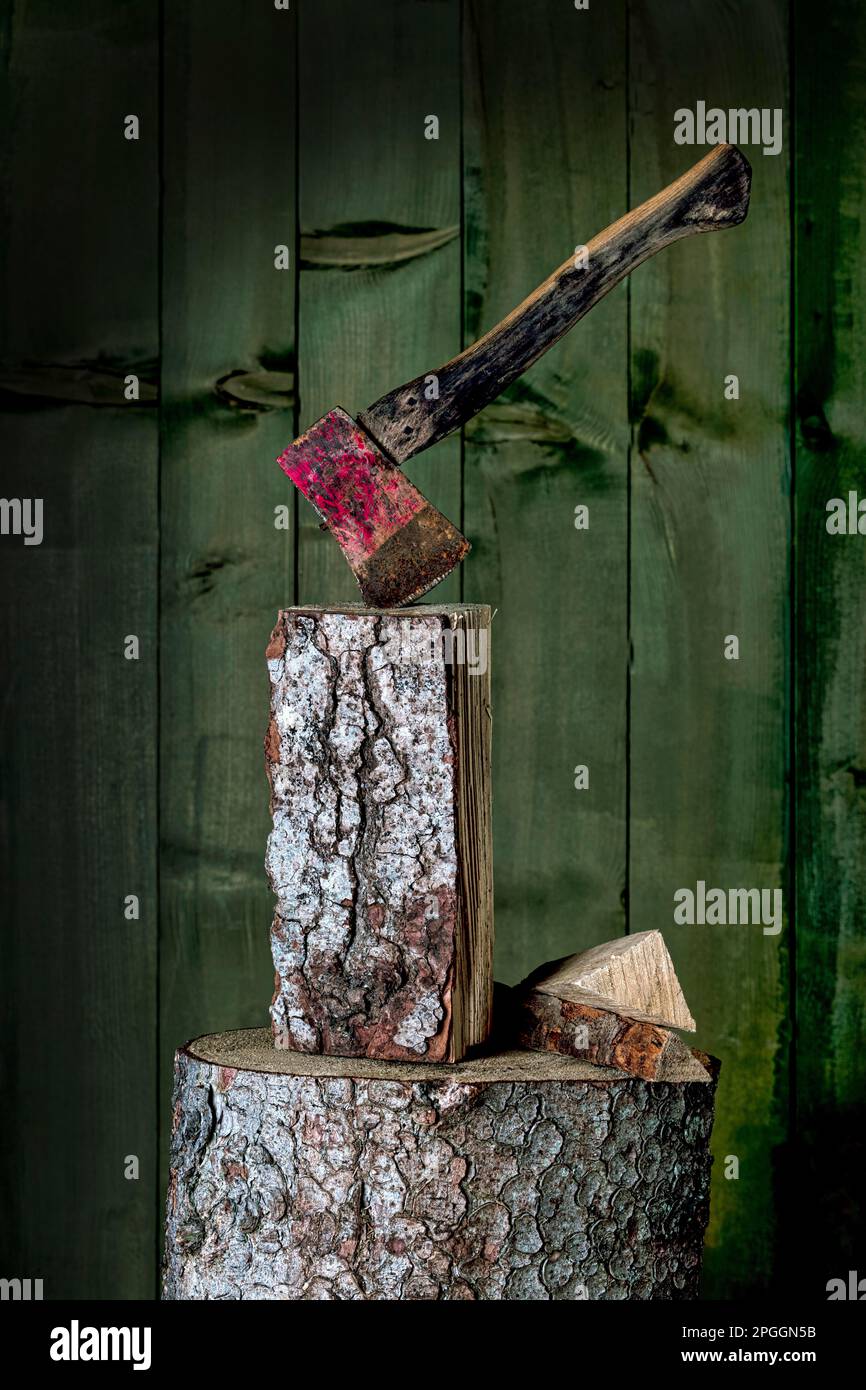 Axe on chopping block with log in front of green wooden wall, studio shot, Germany Stock Photo ...