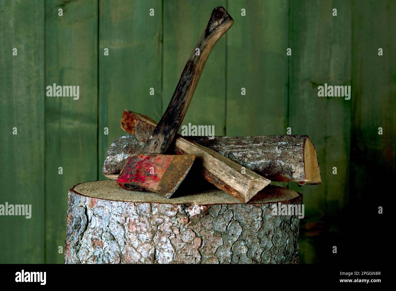 Axe on chopping block with log in front of green wooden wall, studio shot, Germany Stock Photo ...