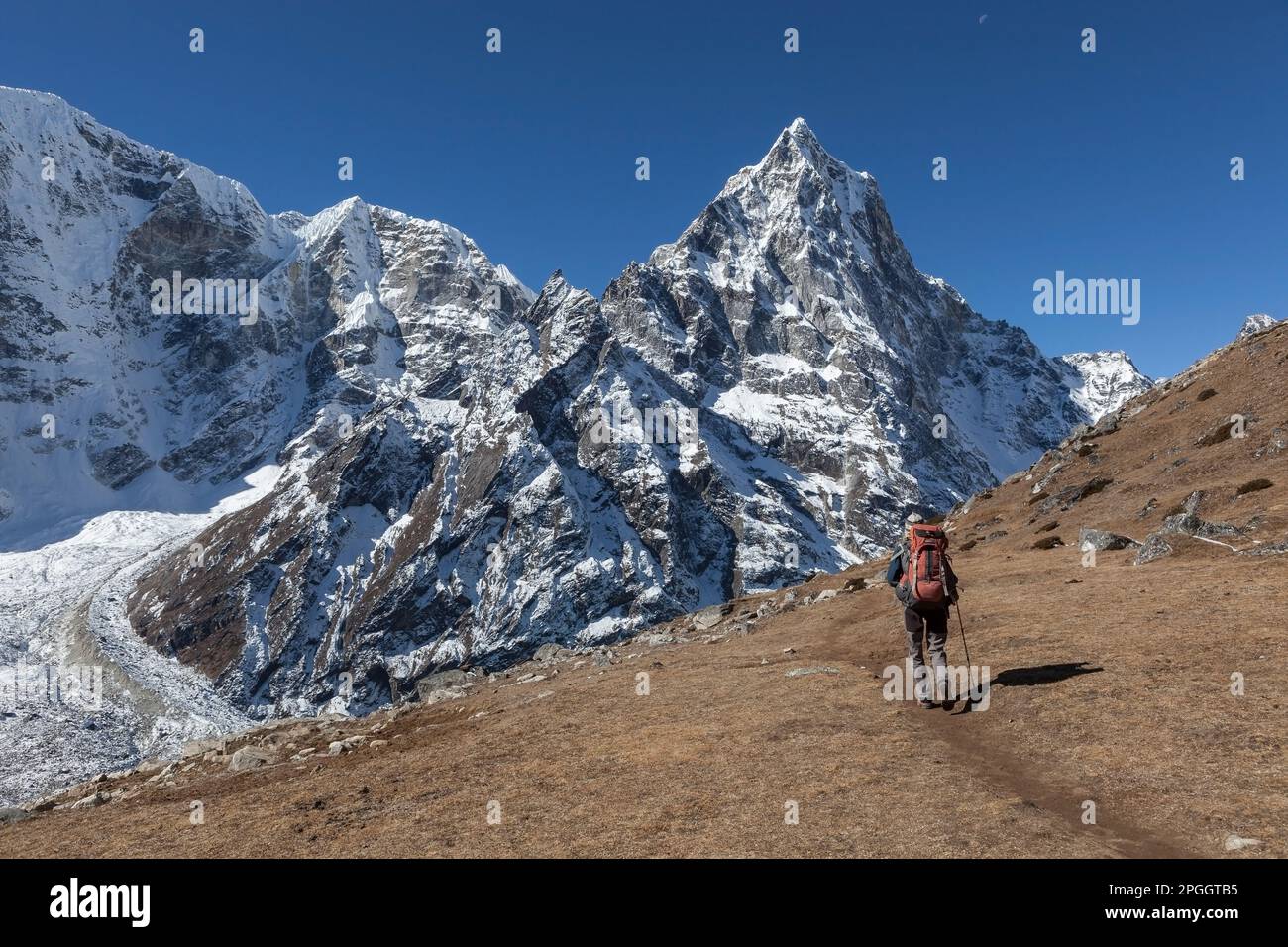 Active woman hiker trekking in Nepal towards a high mountain peak in ...