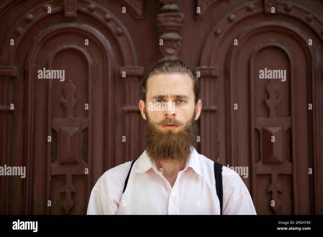 Portrait of bearded hipster in front of a door. Style and diversity ...