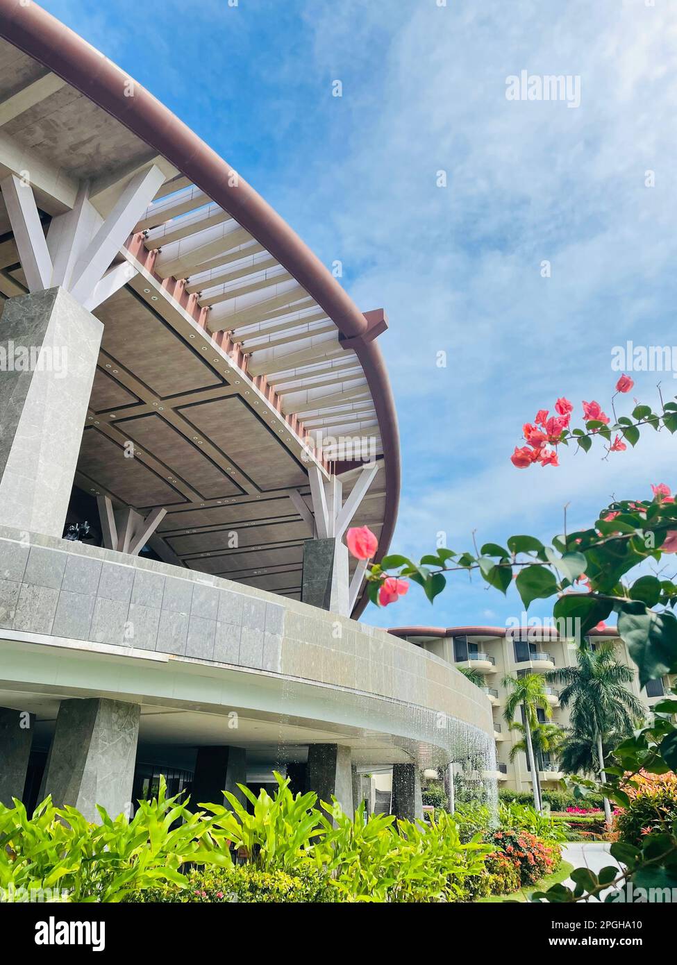Photo of a circular building surrounded by lush green foliage Stock ...