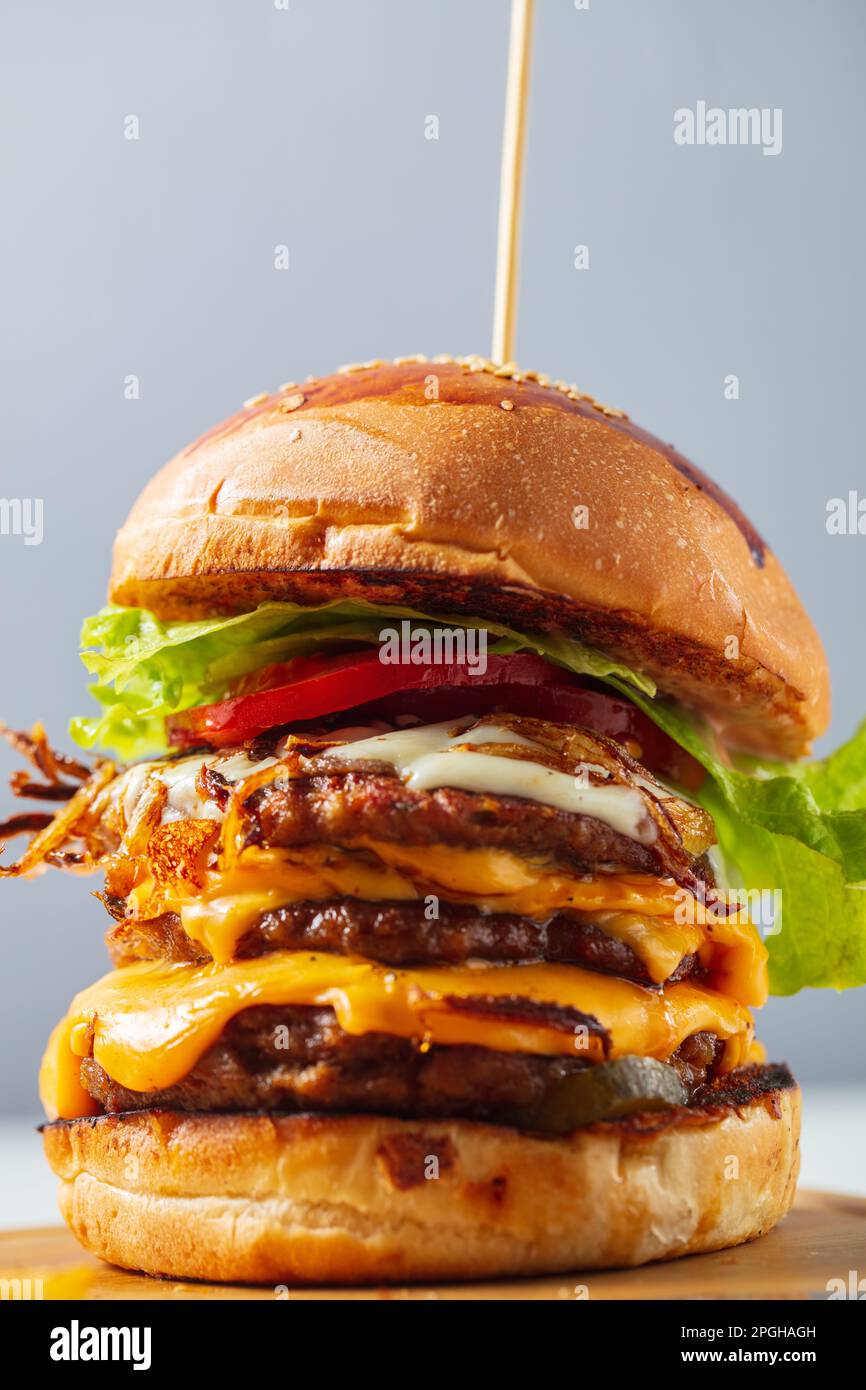 Loaded cheeseburgers three triple, stacked patties stacked high with ...