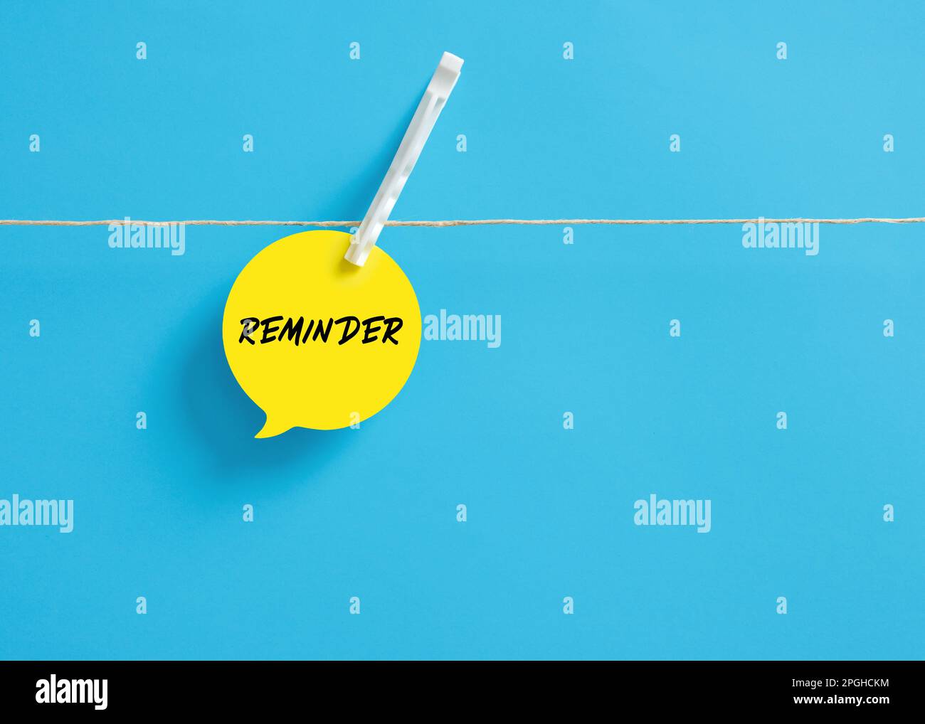 The word Reminder on a speech bubble hanging on clothesline with a ...