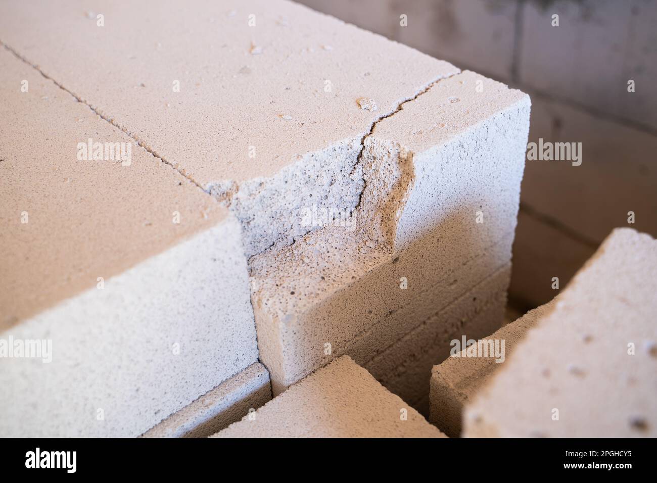 Cracked freshly delivered aerated concrete brick close-up. White porous ...