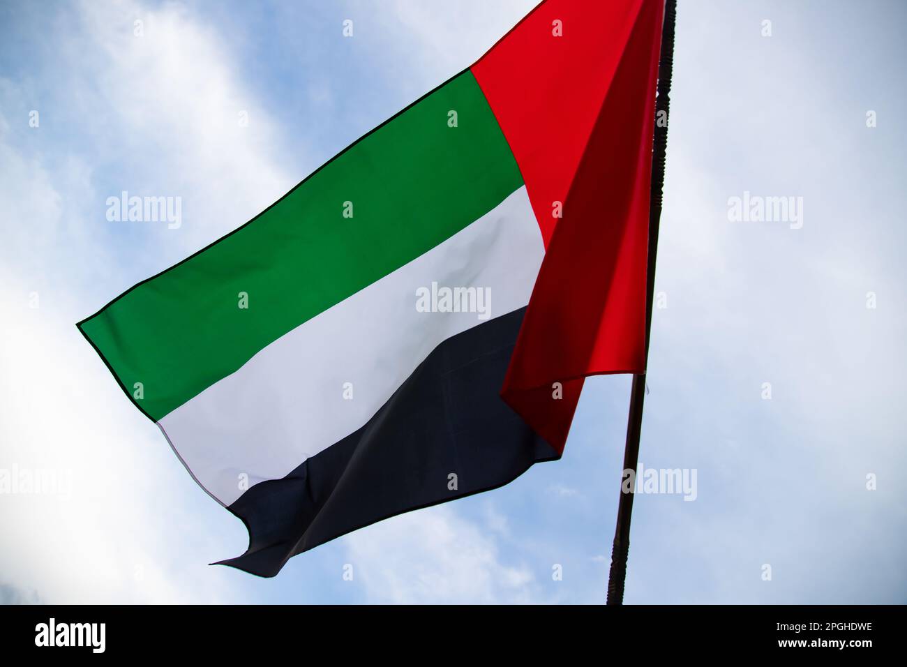 United Arab Emirates flag flying against clean and tranquil sky. UAE ...