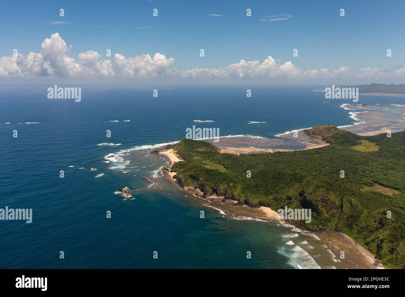 Aerial drone of tropical island with jungle and blue sea. Cape Engano ...