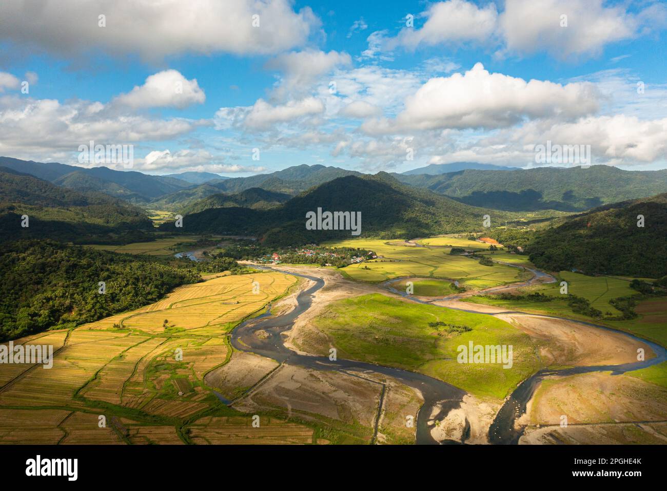 Aerial view of valley with farm fields and a river among the mountains ...