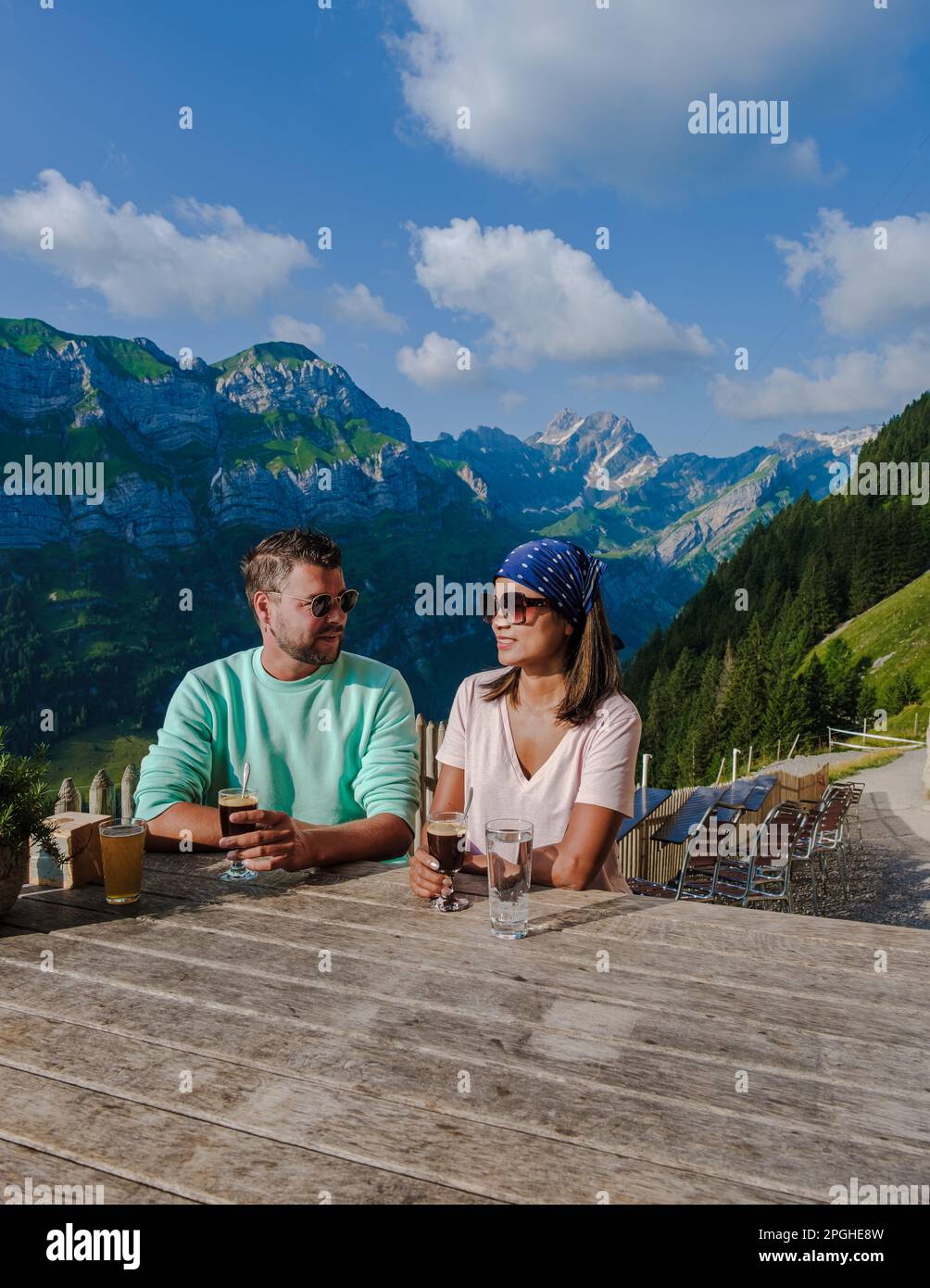 A couple of men and women drinking coffee at Berggasthaus Aescher in ...