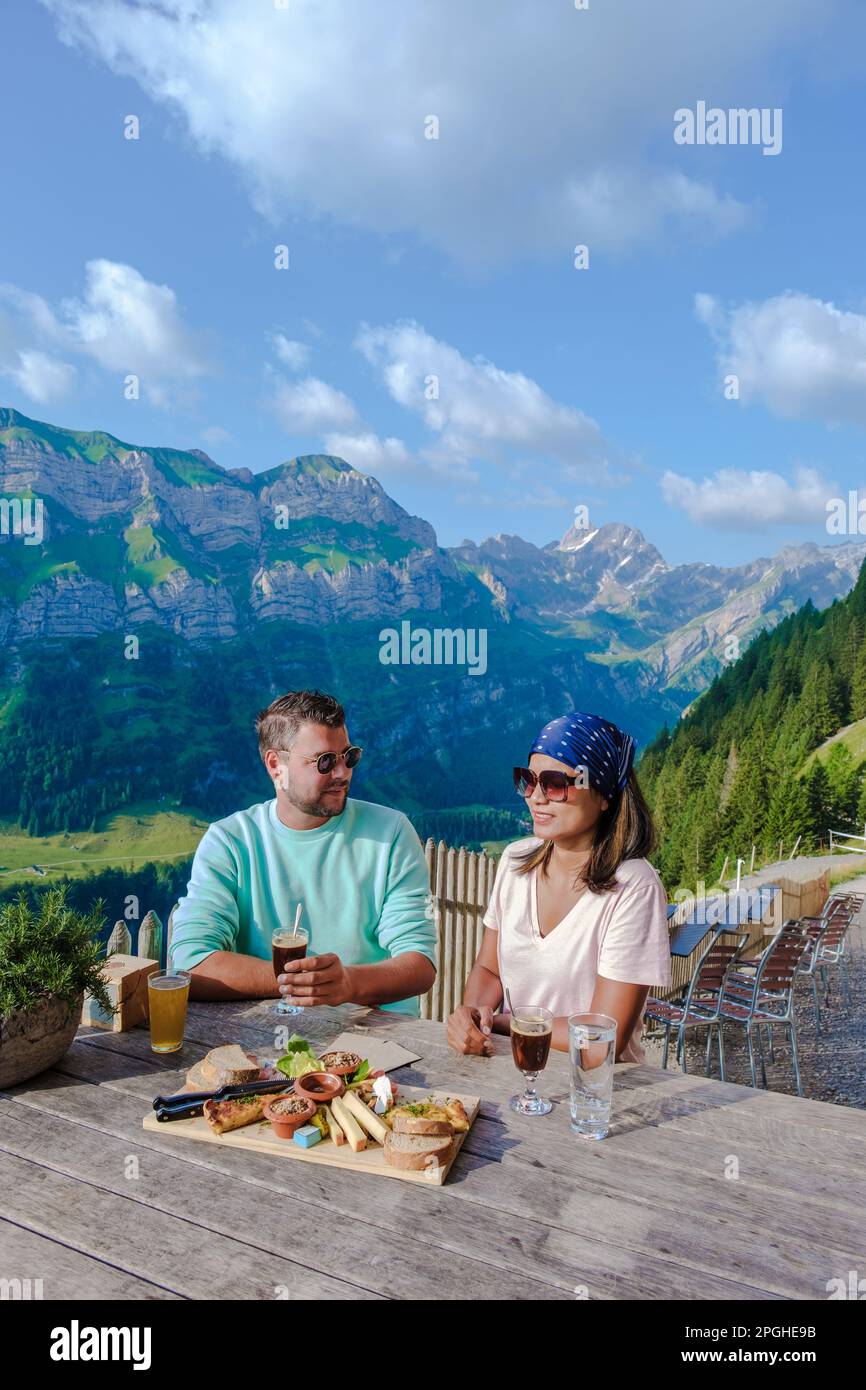 A couple of men and women drinking coffee at Berggasthaus Aescher in ...