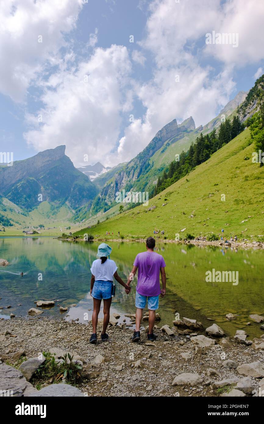 A couple of men and women visiting the Seealpsee lake in den ...