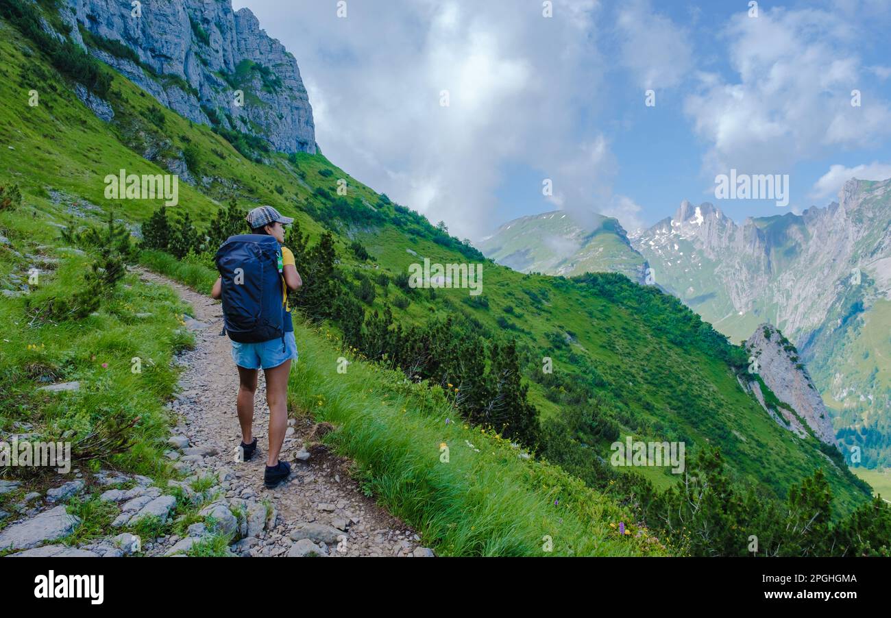 Asian women hiking in the Swiss Alps mountains during summer vacation ...