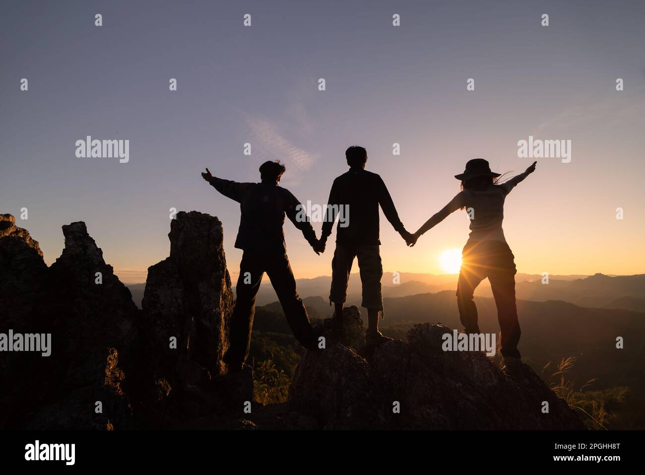 Silhouettes of three people climbing on mountain and helping. Help and ...