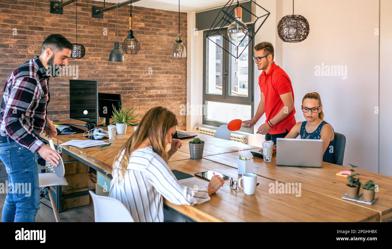 Businessmen having fun playing with a basket ball in coworking office ...