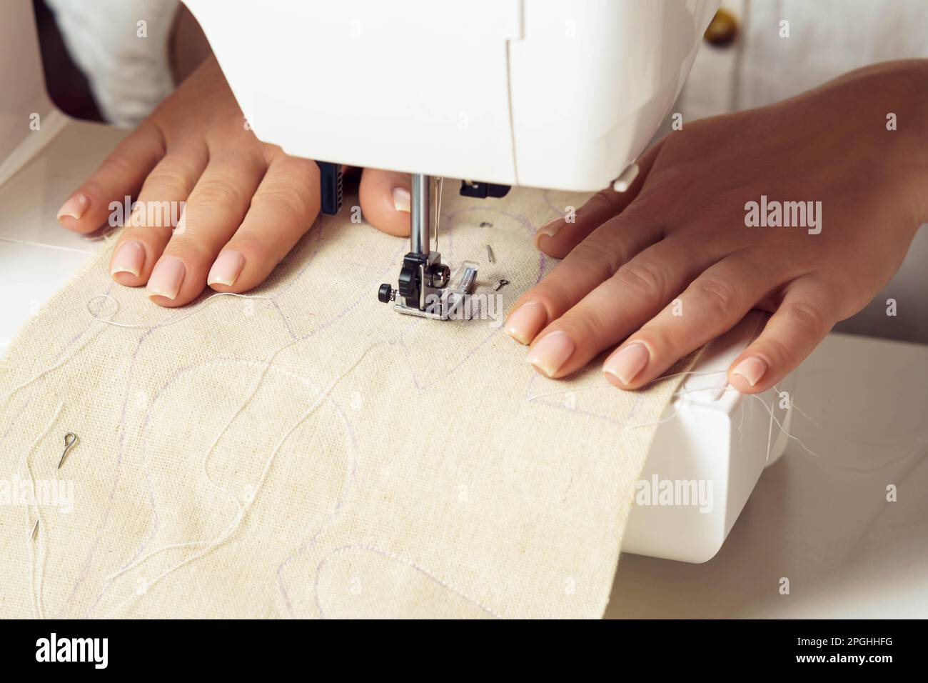 Unrecognizable female tailor hands putting white fabric textile pattern ...