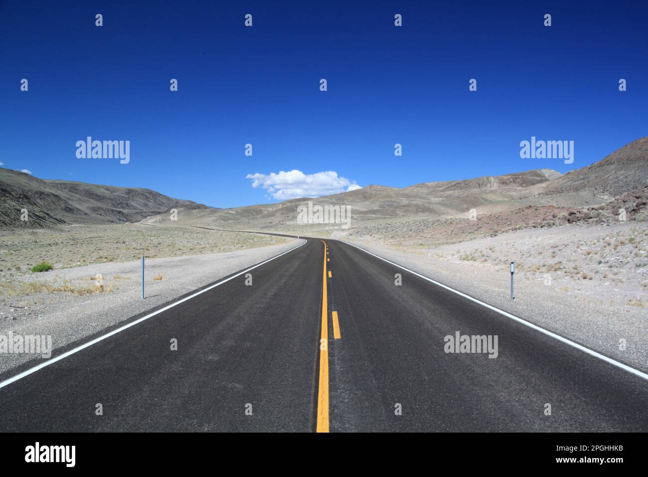 A long, straight highway winding its way through a vast desert ...