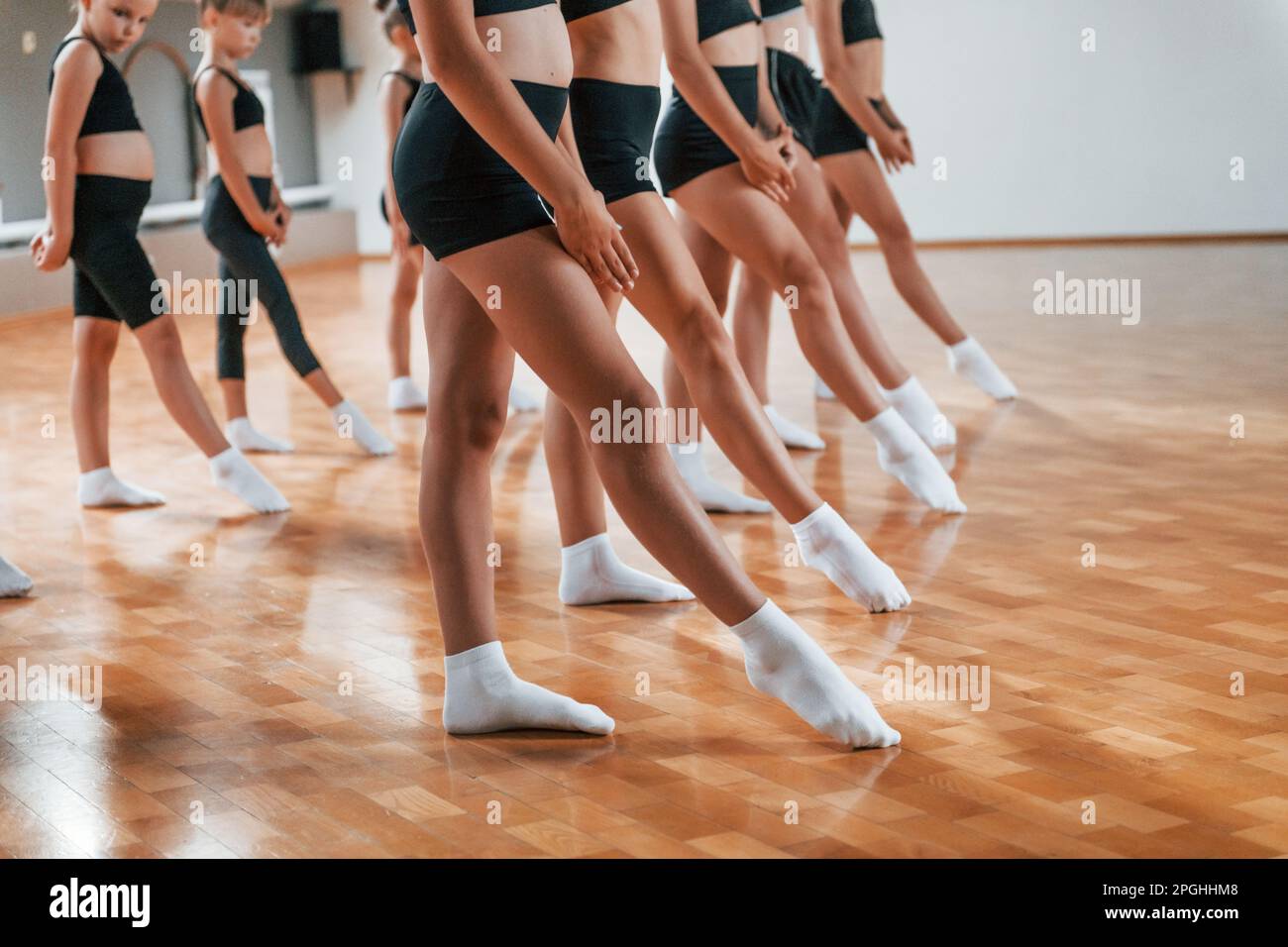 Group of female kids practicing athletic exercises together indoors ...