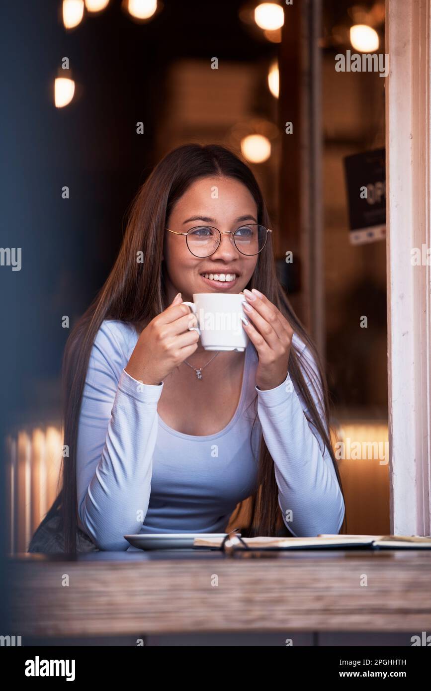 Thinking, dark and happy with a woman in a coffee shop, sitting a table ...