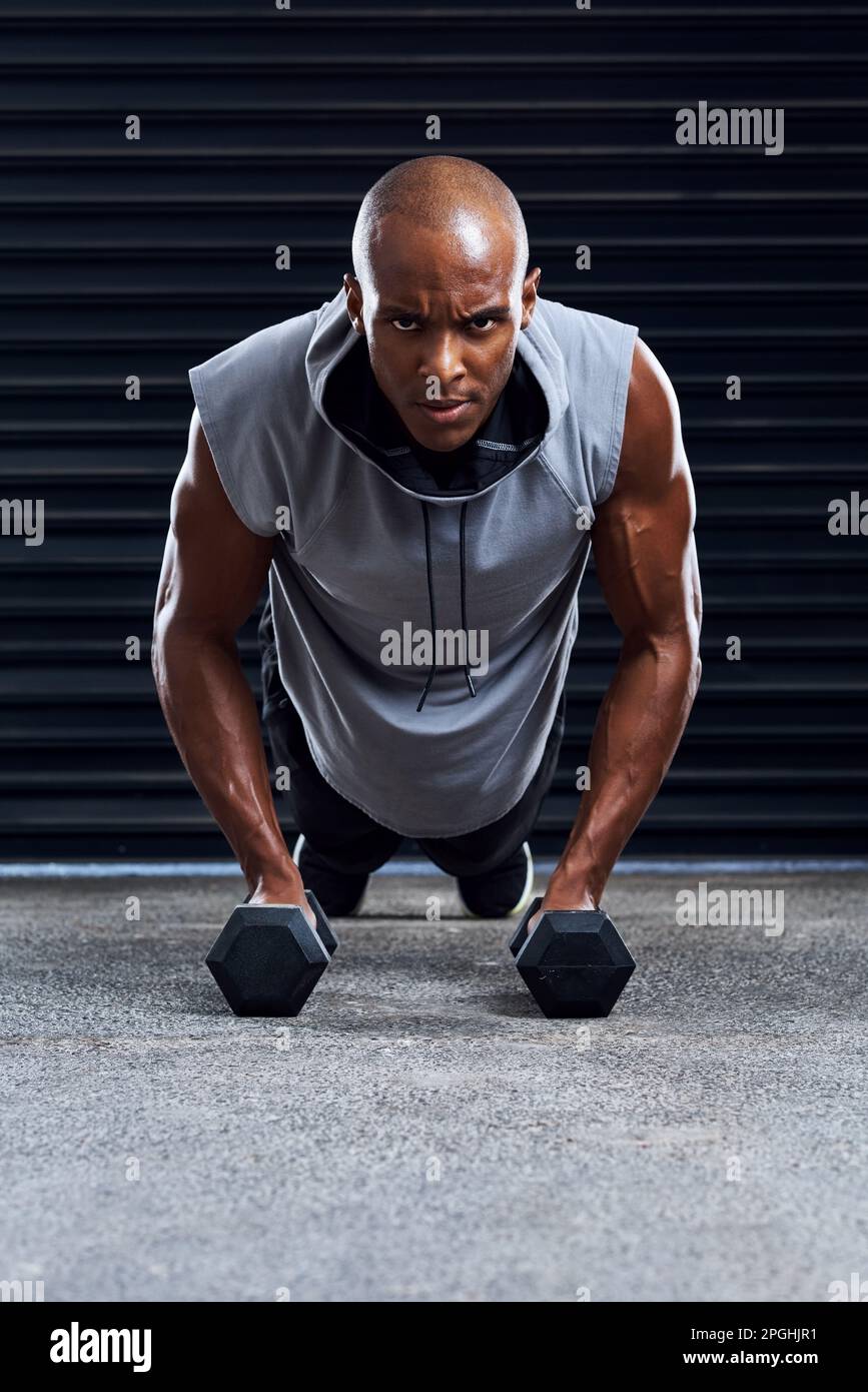 Follow your inner beast. a sporty young man working out with dumbbells ...