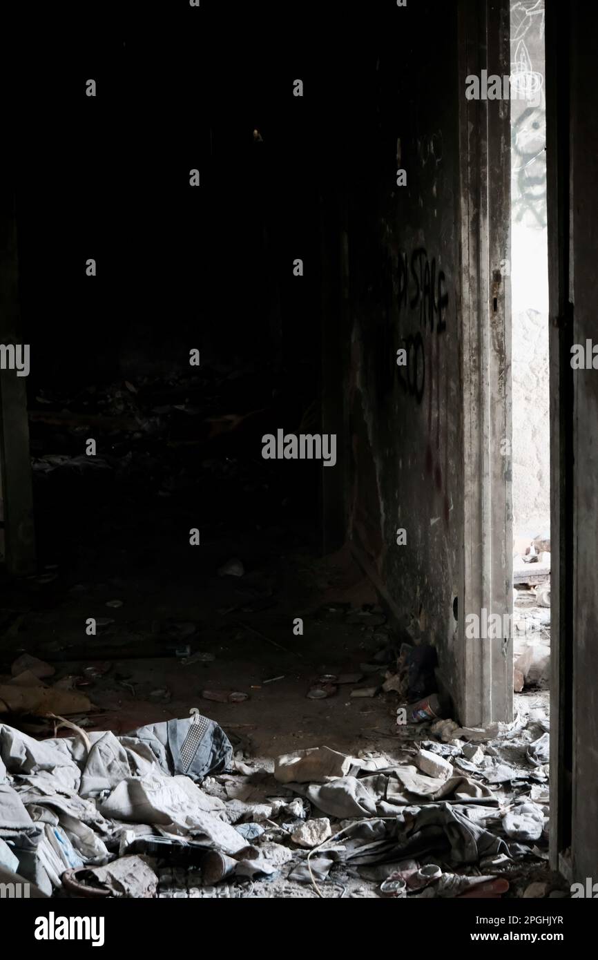 A dimly lit indoor corridor with scattered garbage on the floor Stock ...