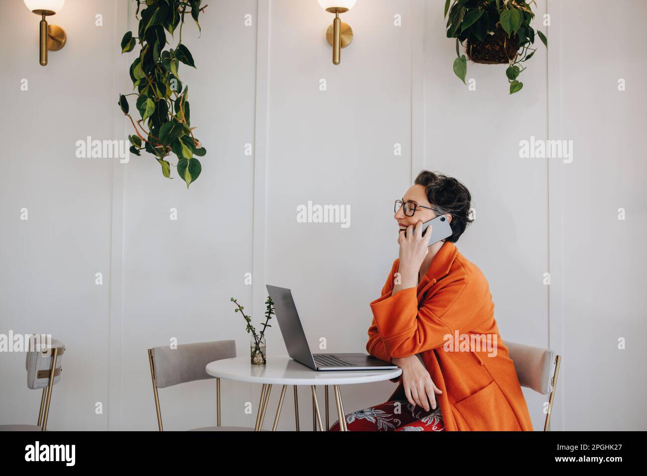 Successful business woman speaking on a phone call while working ...