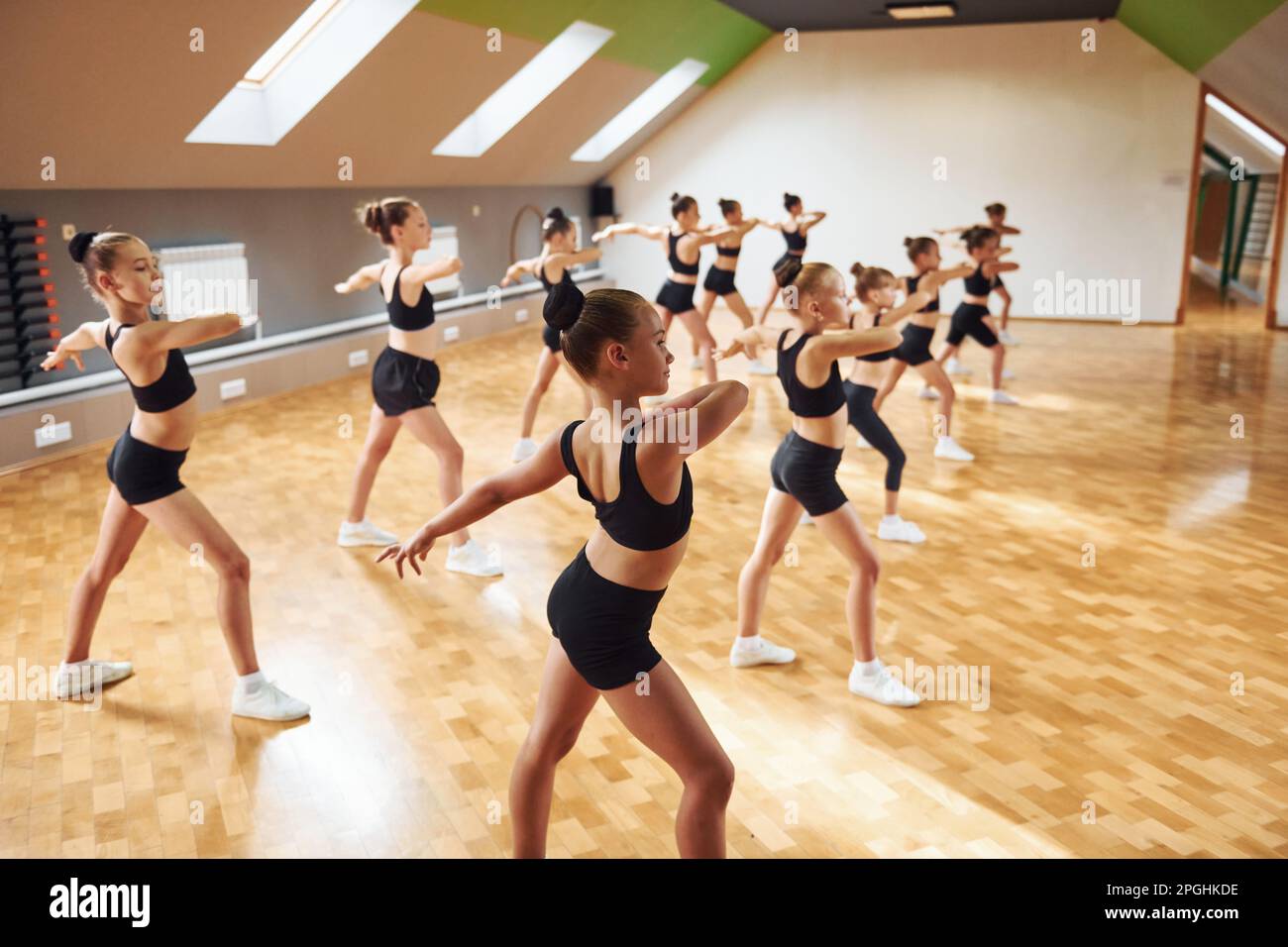 Side view of group of female kids that practicing athletic exercises ...