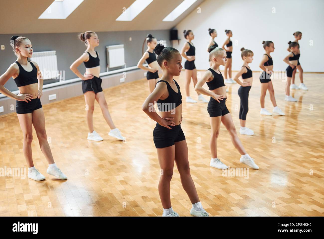 Side view of group of female kids that practicing athletic exercises ...