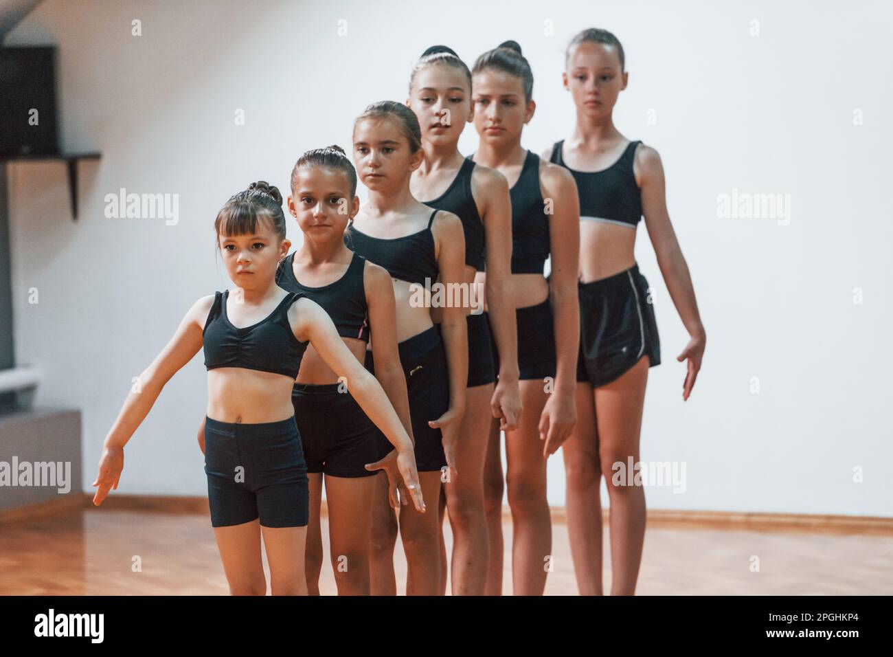 Daily routine. Group of female kids practicing athletic exercises ...