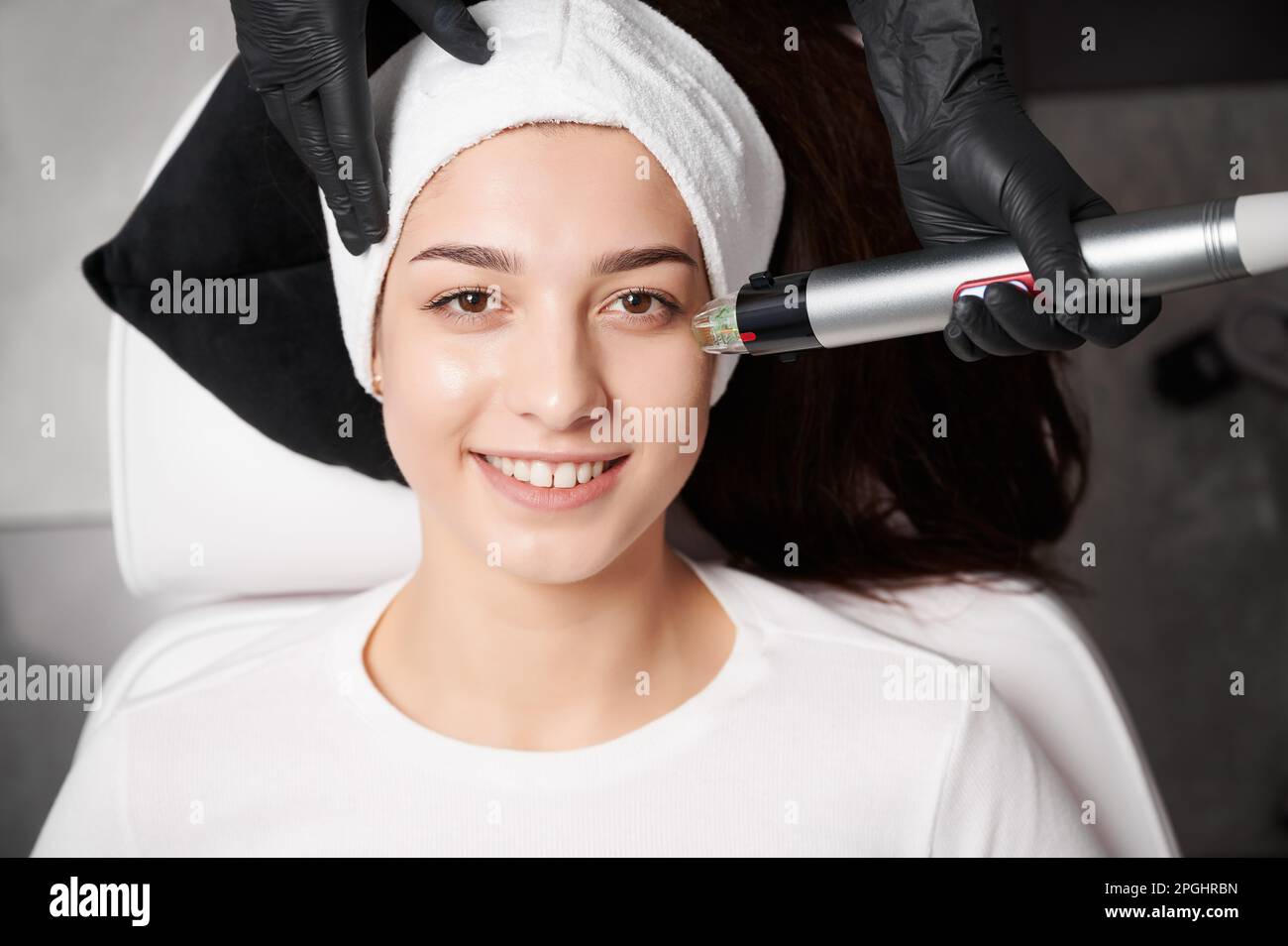 Top view of medical esthetician using radiofrequency device while ...