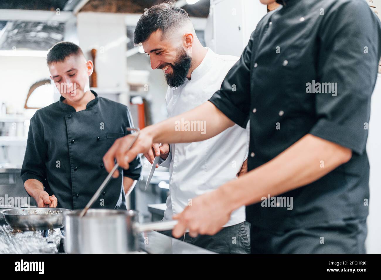Group of people cooking food at kitchen together. Busy day at work ...