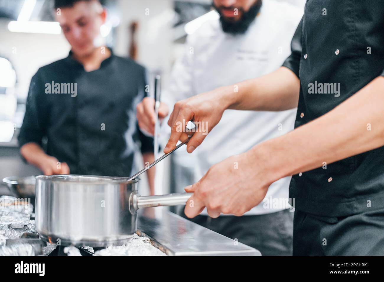 Group of people cooking food at kitchen together. Busy day at work ...