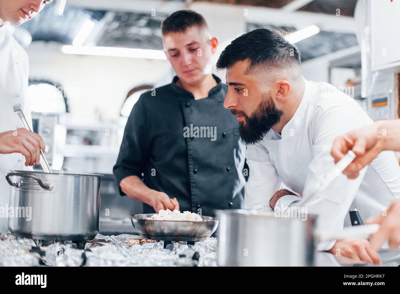 Group of people cooking food at kitchen together. Busy day at work ...
