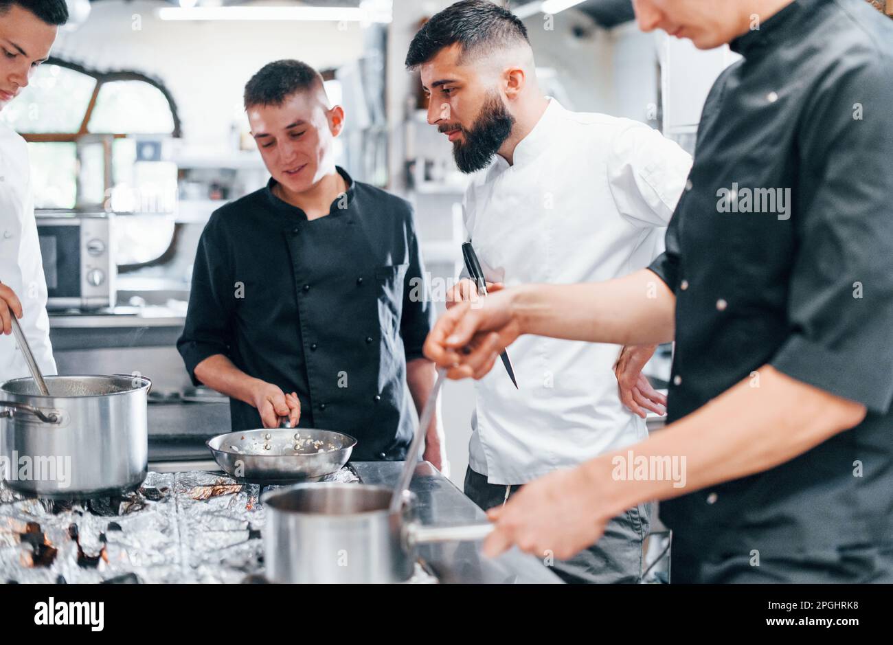Group of people cooking food at kitchen together. Busy day at work ...