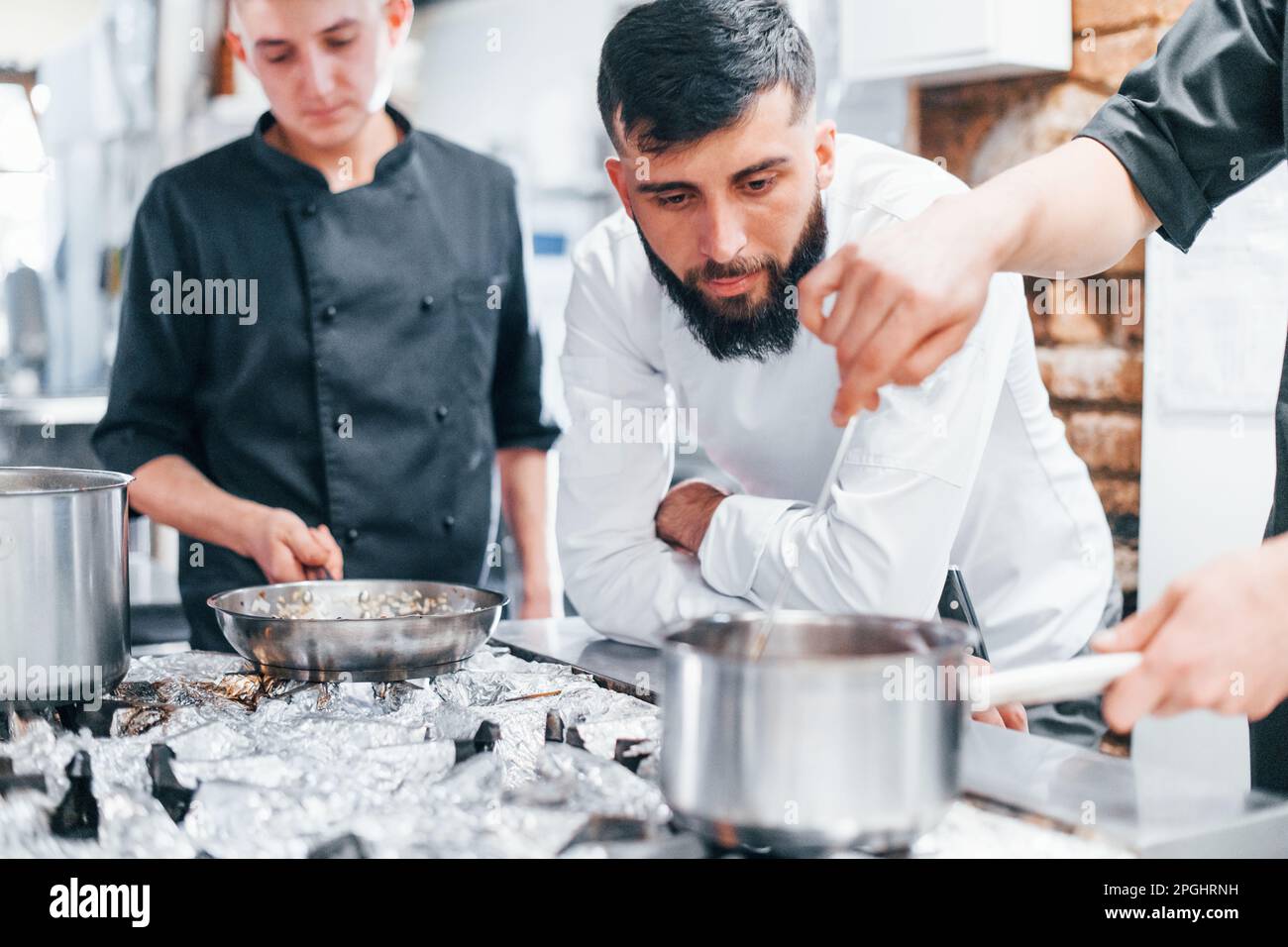 Group of people cooking food at kitchen together. Busy day at work ...