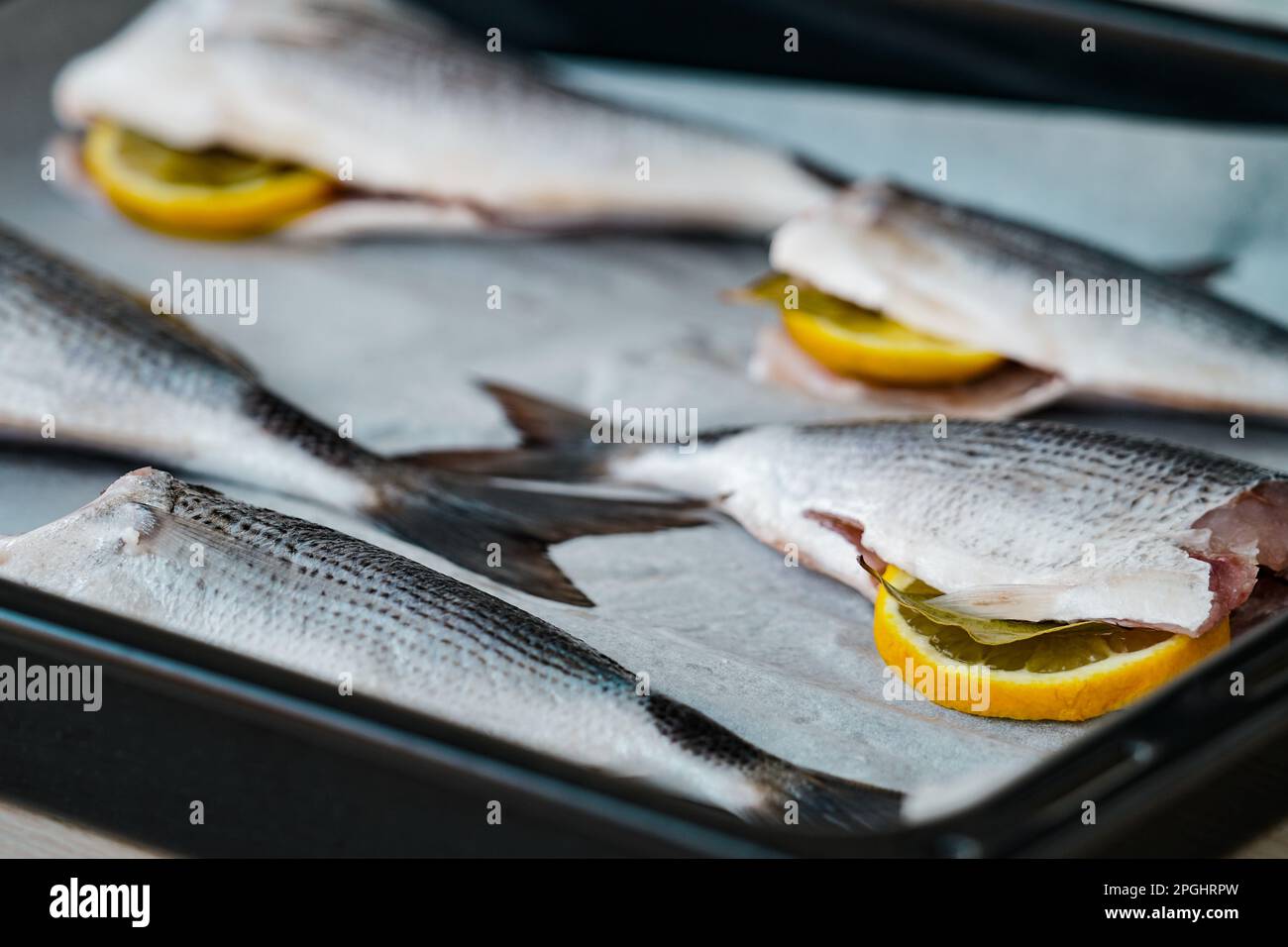 Fish ready on the baking tray sheet and baking paper, lemon daphne, sea ...