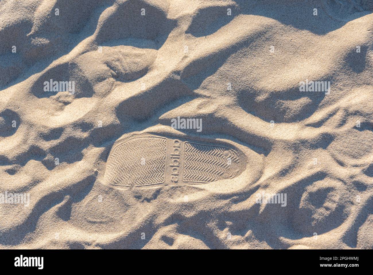 Footprints in the sand with the Adidas brand logo Stock Photo - Alamy