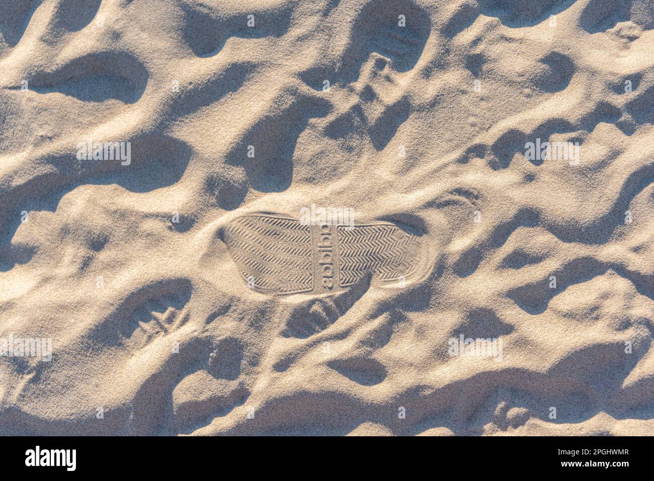 Footprints in the sand with the Adidas brand logo Stock Photo - Alamy