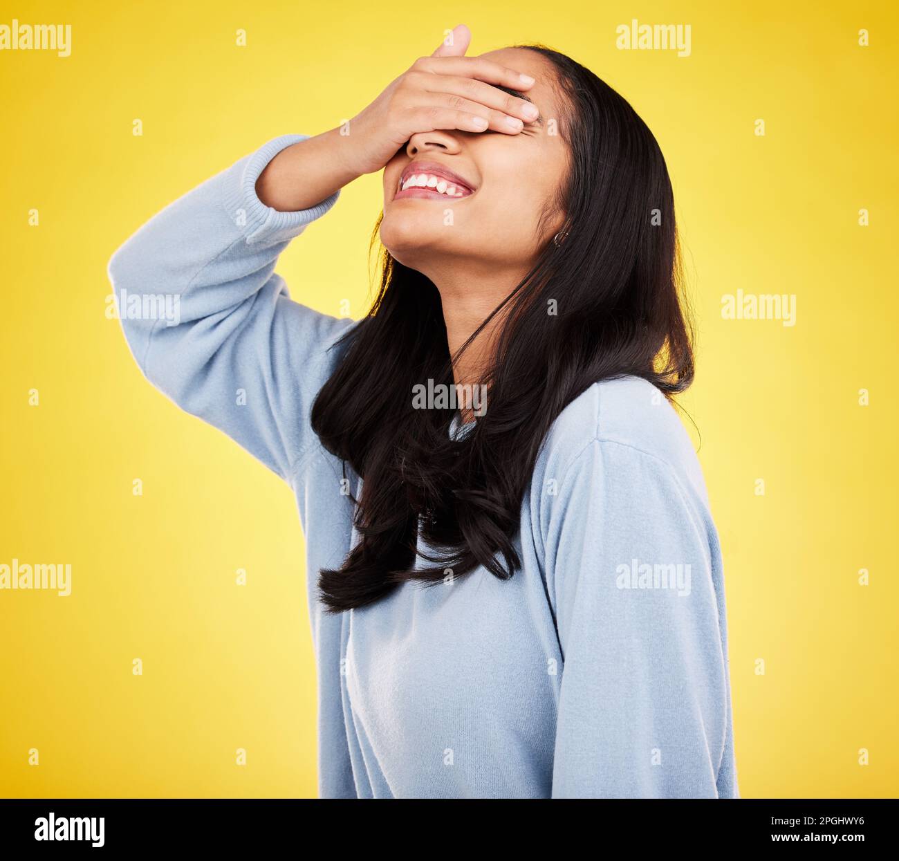 Happy, hands cover eyes and woman with smile in yellow studio for ...