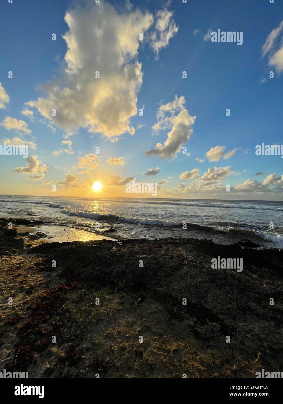 A beautiful, natural sunset over the ocean horizon, with soft, wispy ...