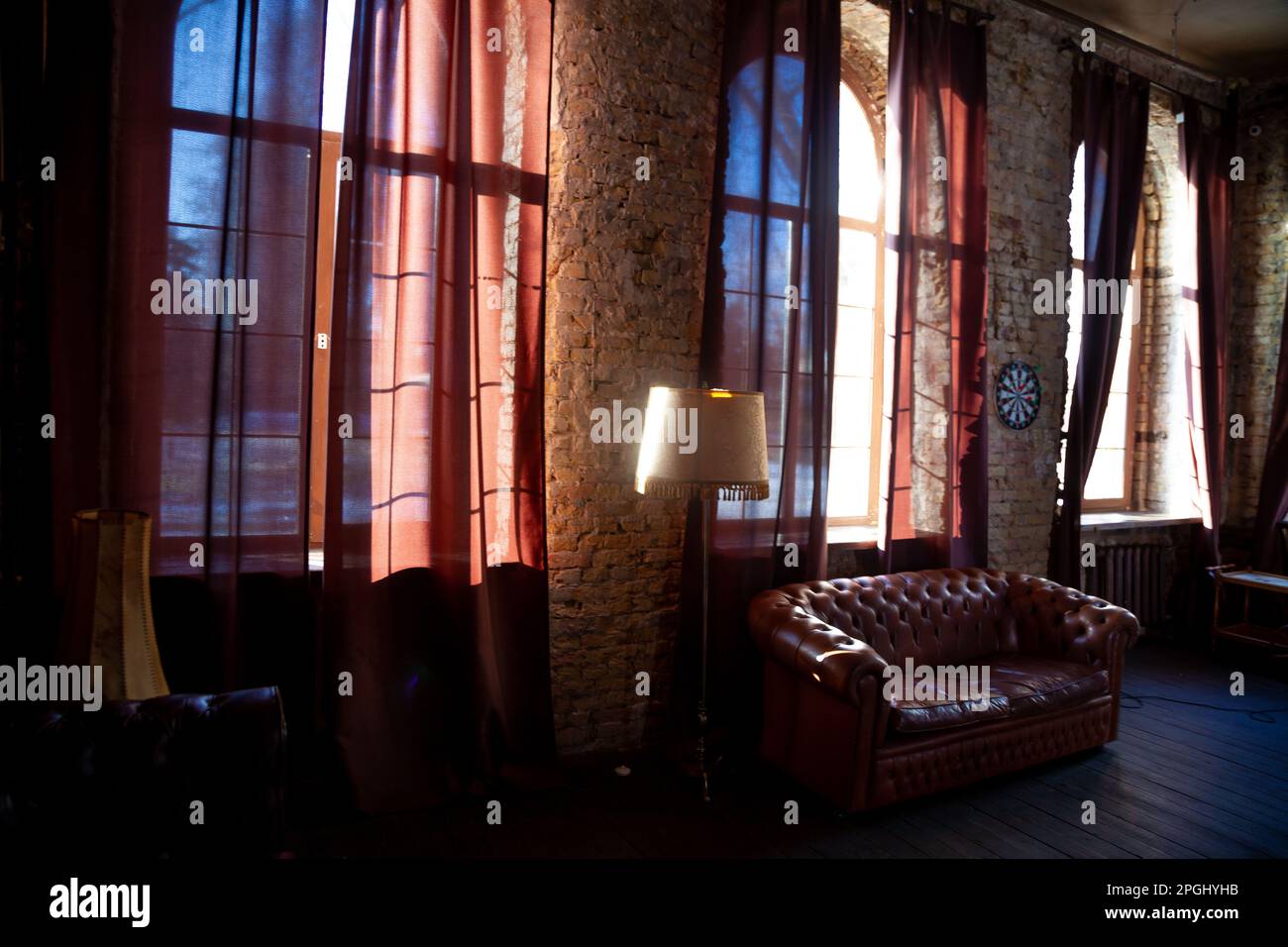 Windows at empty Library room with a brick wall. Leather sofa in a ...