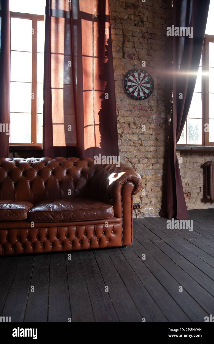 Windows at empty Library room with a brick wall. Leather sofa in a ...