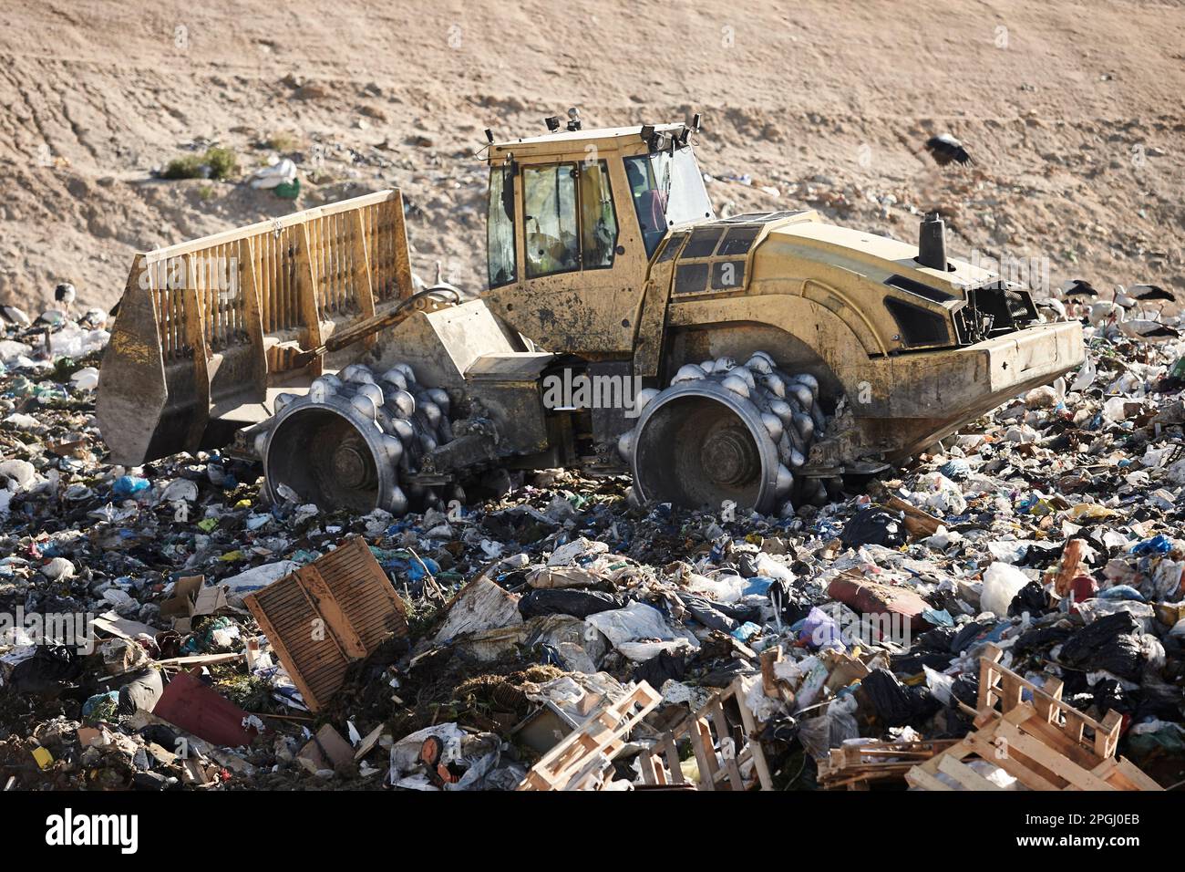 Heavy machinery shredding garbage in an open air landfill. Waste Stock ...