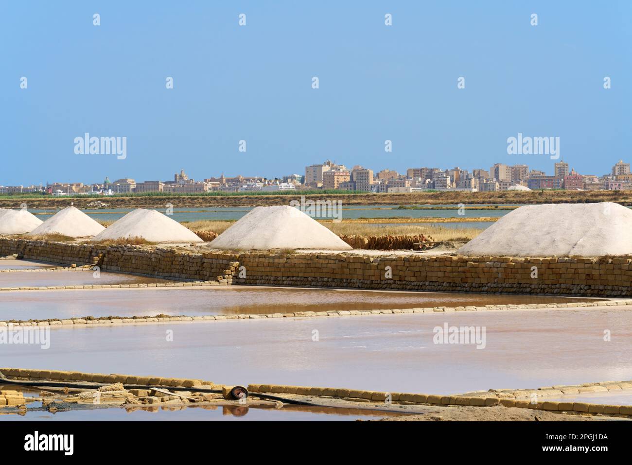 The salt pans of Trapani in Sicily, Italy. A few heaps of coarse salt ...