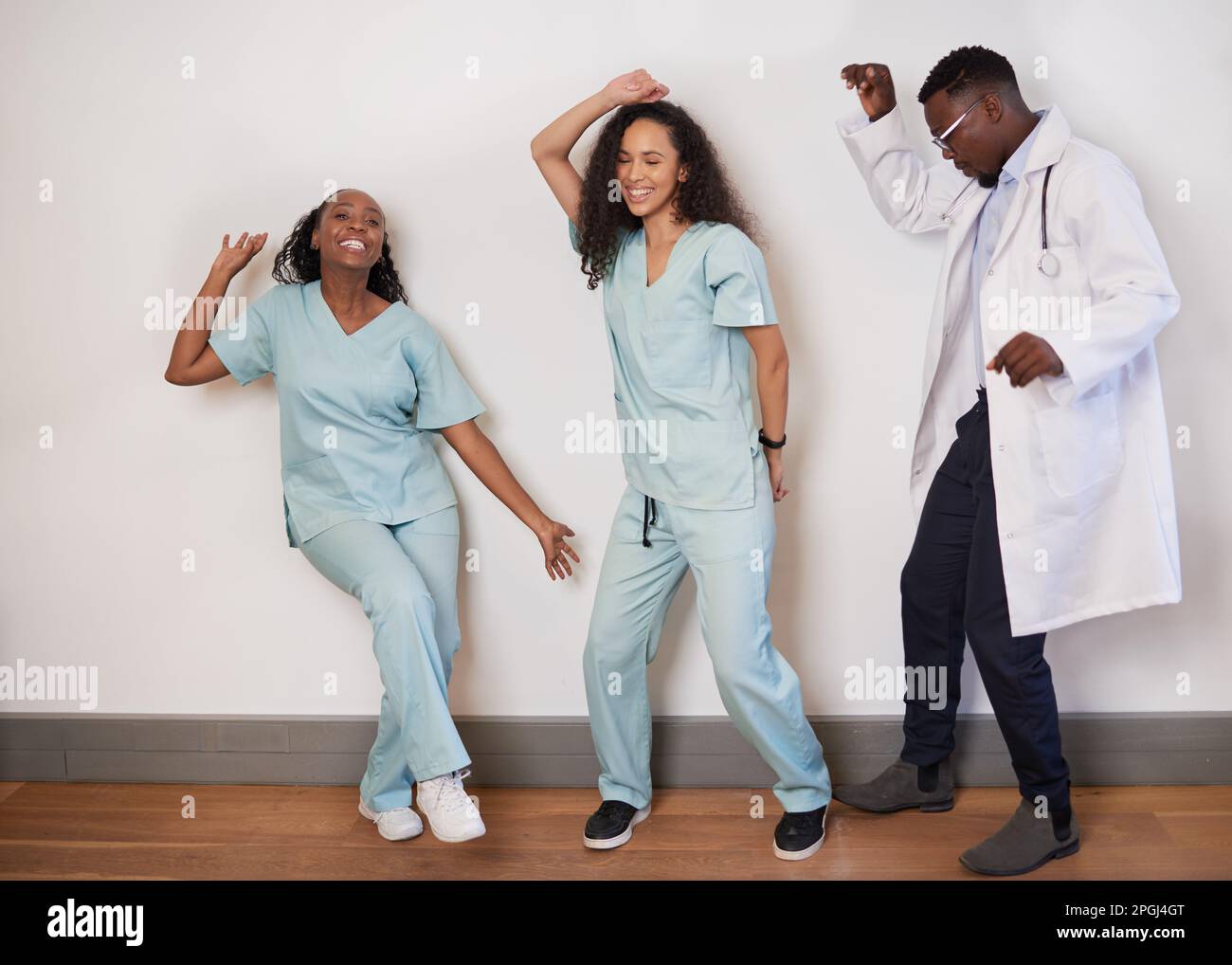 Team of three medical professionals dance on a break, doctor having fun ...