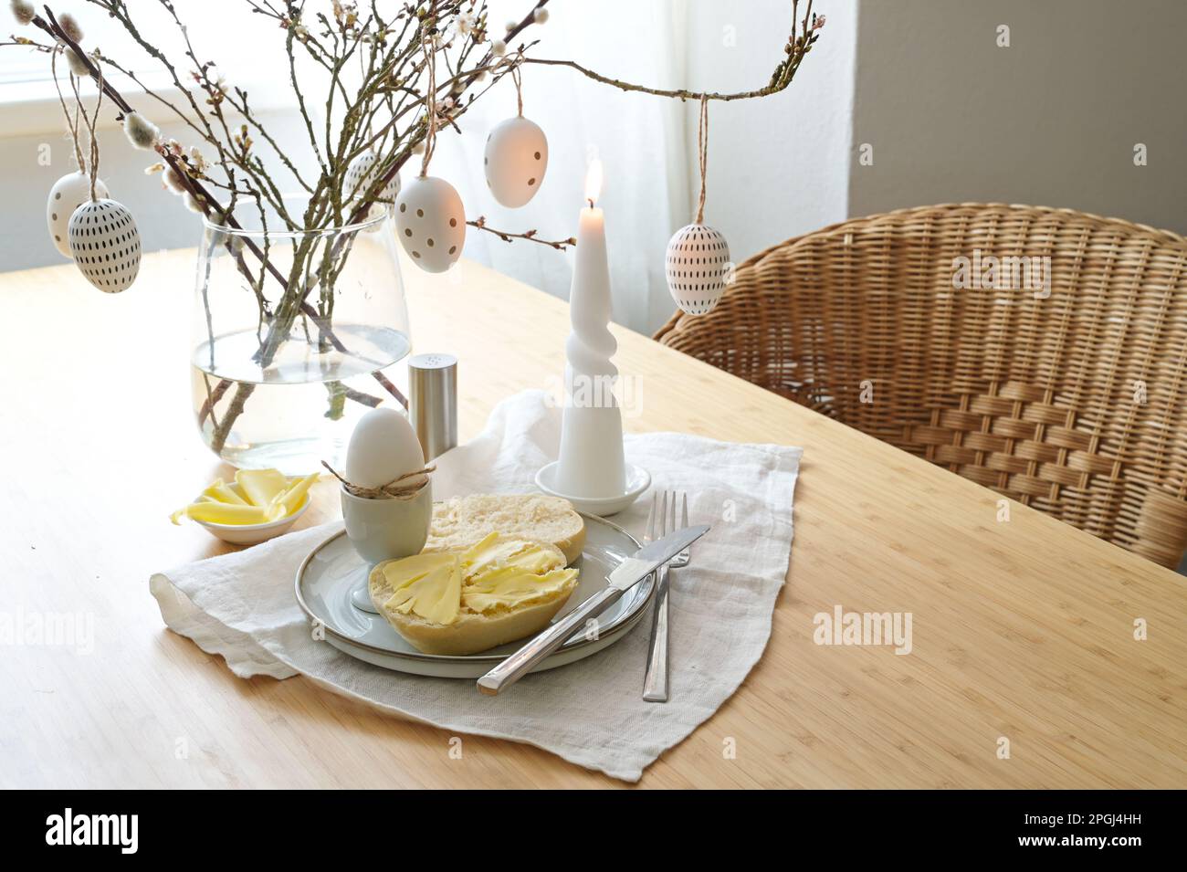 Easter breakfast for one, patterned eggs hanging on spring branches ...