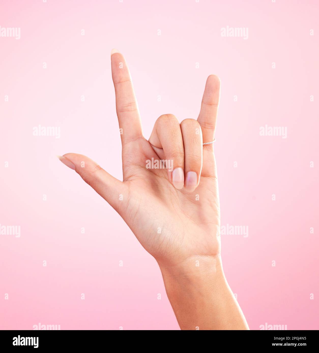 Hands, closeup and woman in studio with rock and roll sign, gesture or ...